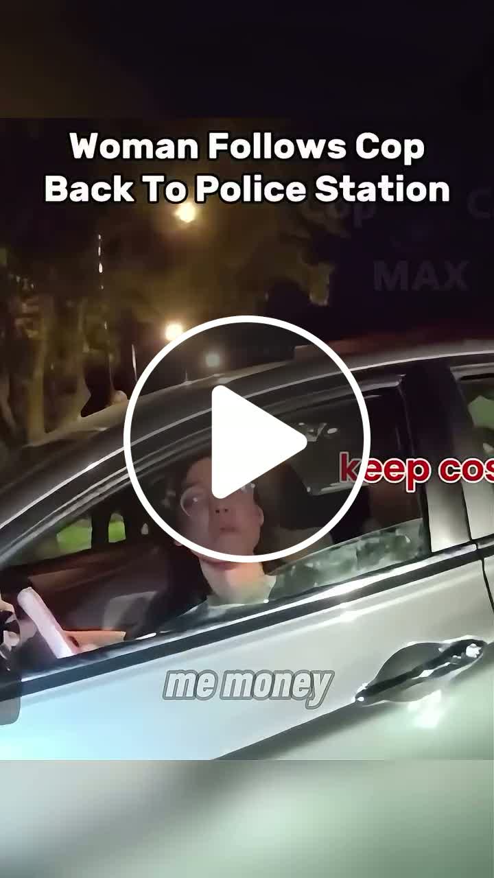 A woman follows an officer back to the police station after she got a ...