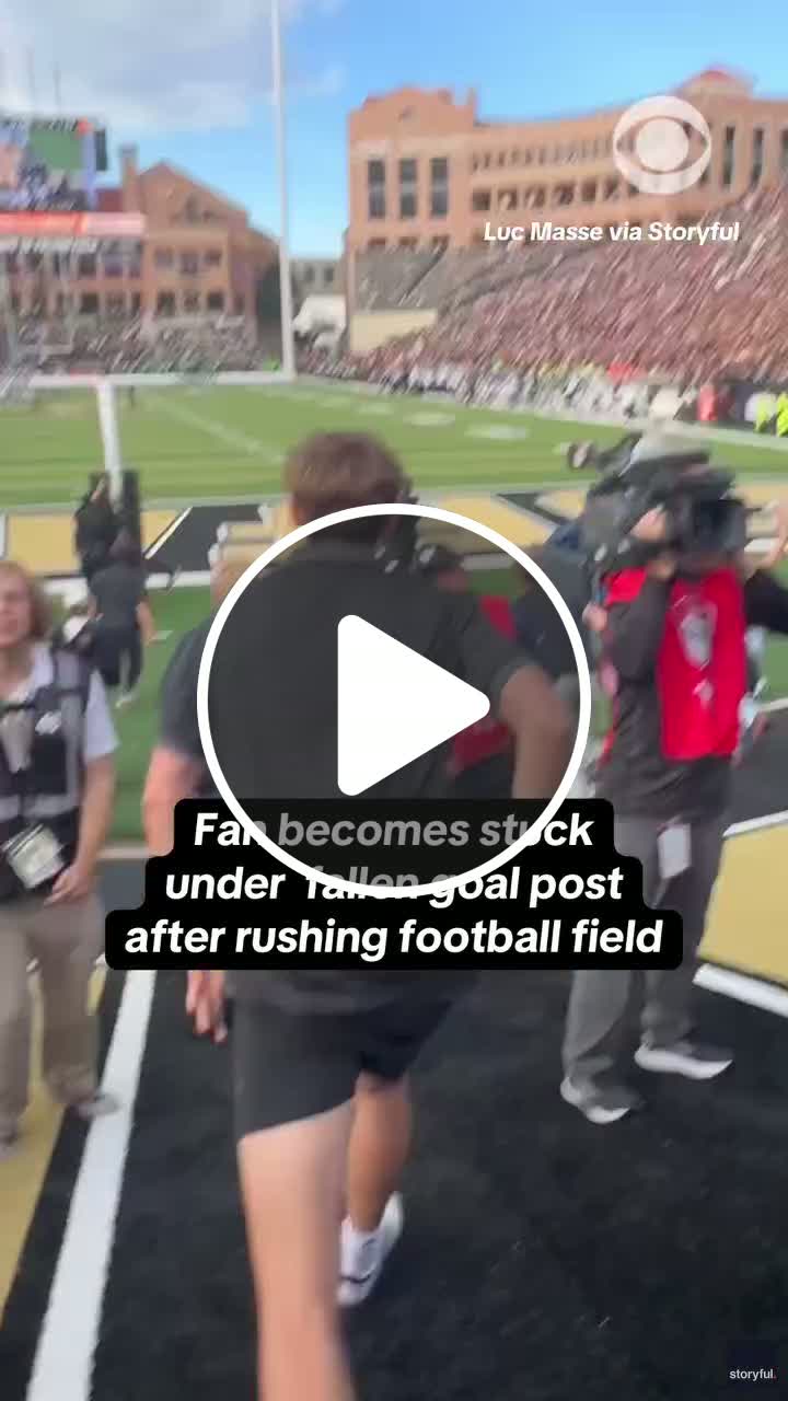 Fan becomes stuck under fallen goal post after rushing football field# ...
