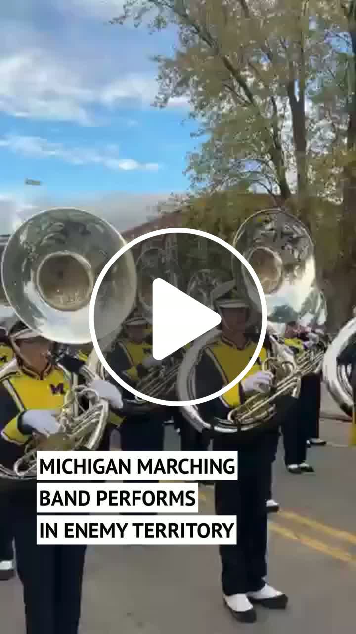 The Michigan Marching Band performs in enemy territory, walking toward ...