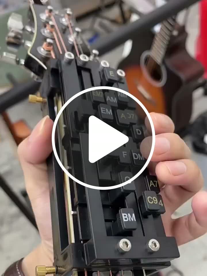 A device that attaches to a guitar, using buttons to press chords ...