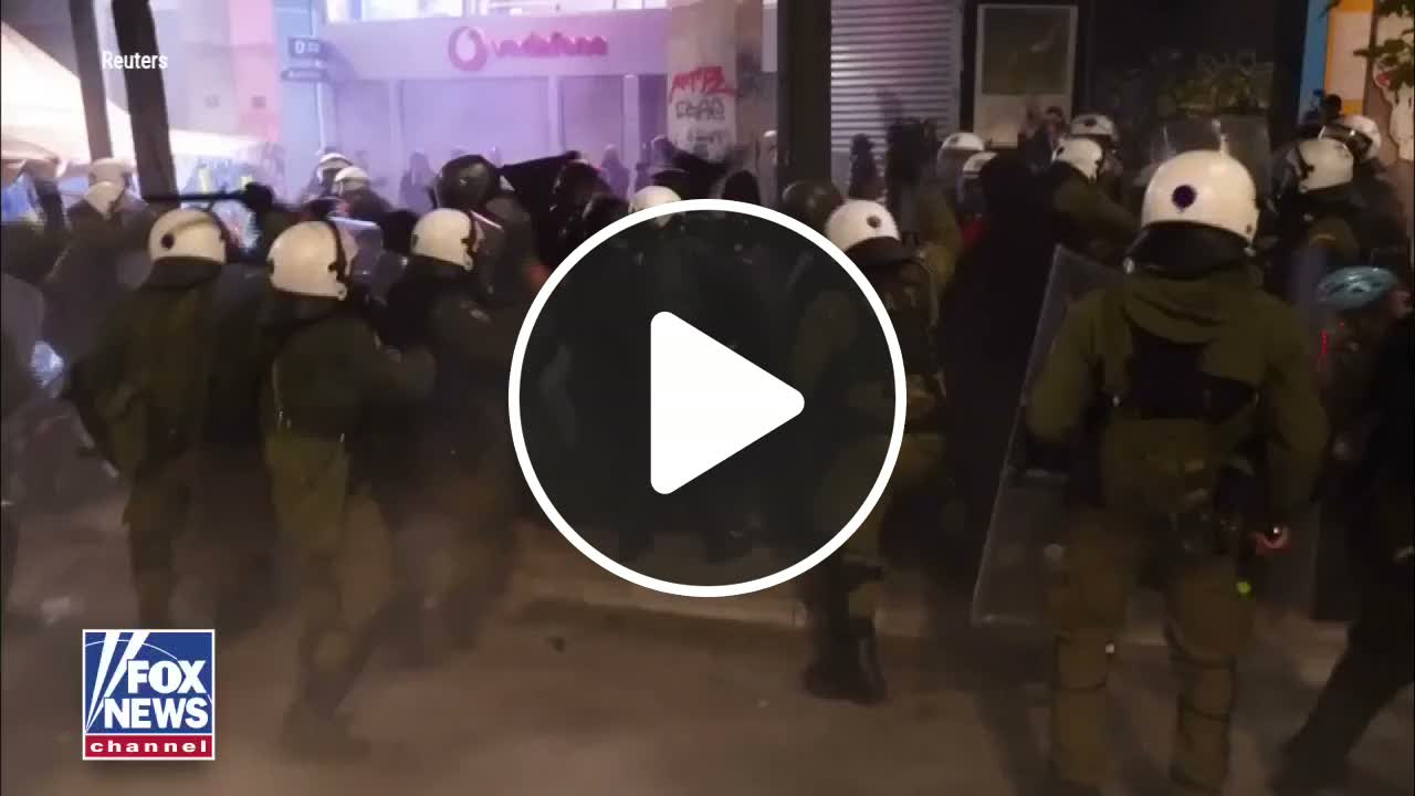 Riot police strike protesters with batons on the streets of Athens ...