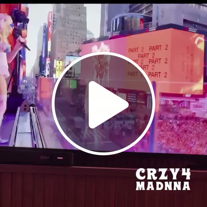 Madonna dangles her leg over the stage barrier at Times Square pop up ...