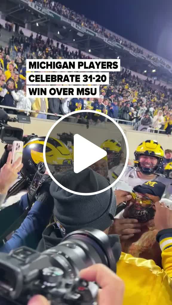 Michigan players hoisted the Paul Bunyan trophy, decorating it with ...